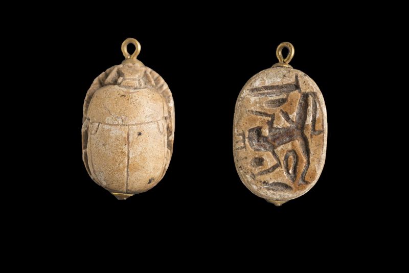 Scarab depicting a king kneeling with raised arms in front of an ...