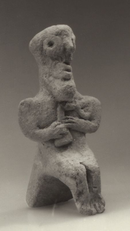 Syrian figurine of a bearded man, seated and holding a curved sickle ...